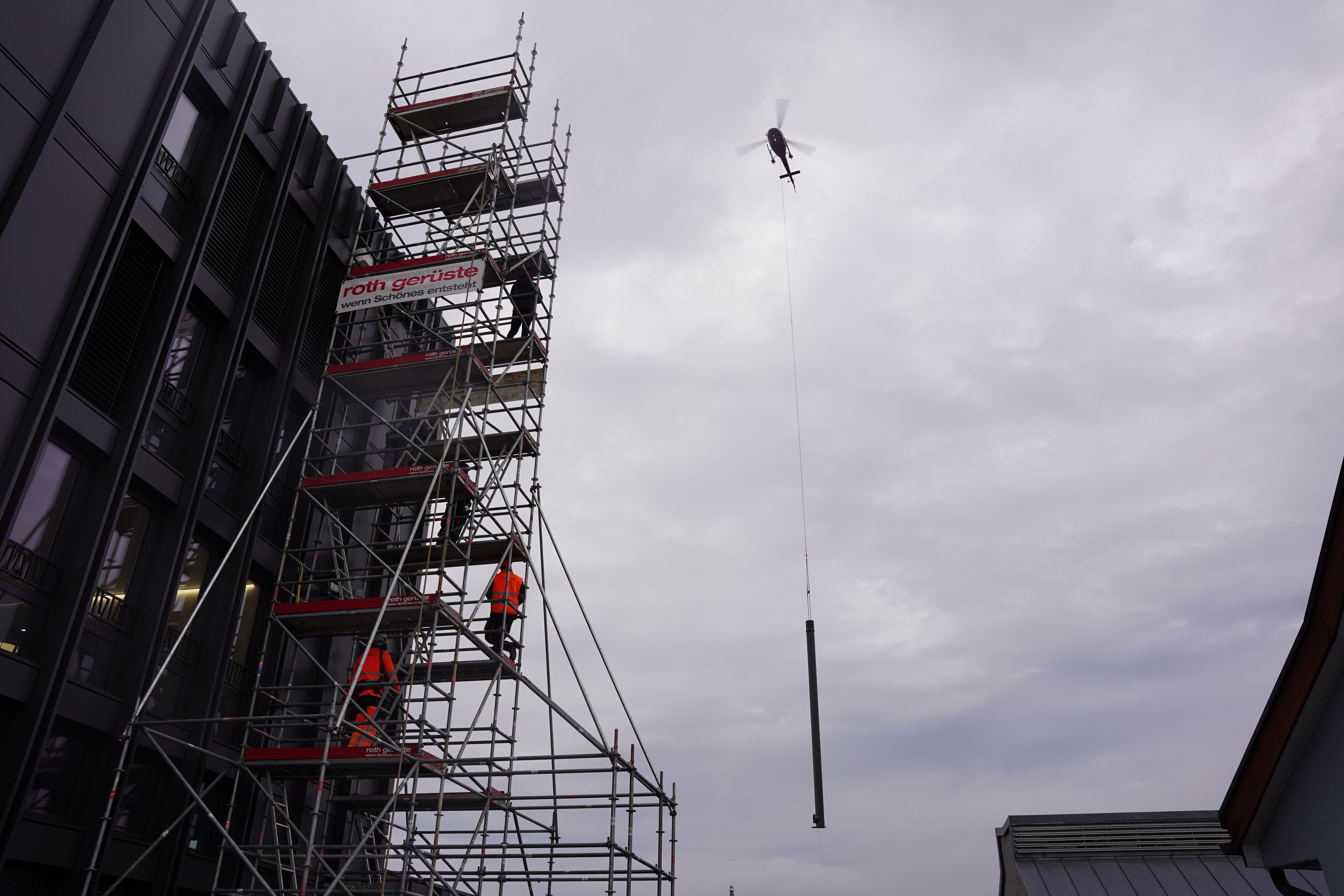Brugg: Helikopter liefert 18 Meter langes Kaminrohr für McDonald's